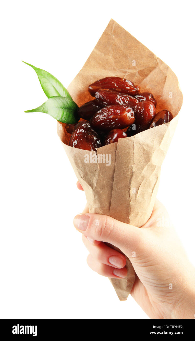 Dried dates in paper cone in hand isolated on white Stock Photo - Alamy