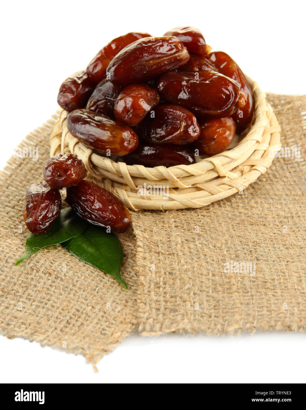 Dried dates on wicker stand sackcloth isolated on white Stock Photo - Alamy