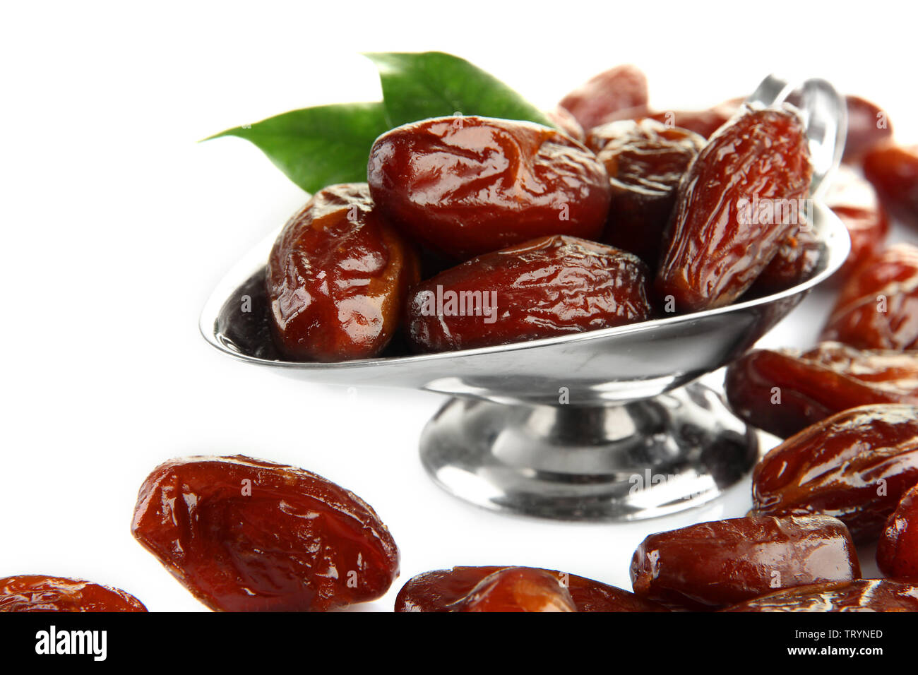 Dried dates in metal dish isolated on white Stock Photo - Alamy