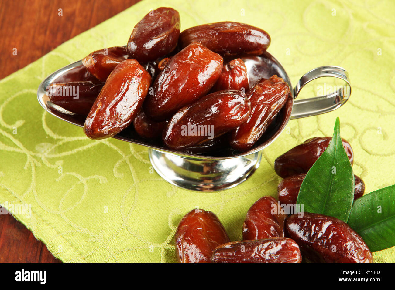 Dried dates in metal dish on fabric background Stock Photo - Alamy