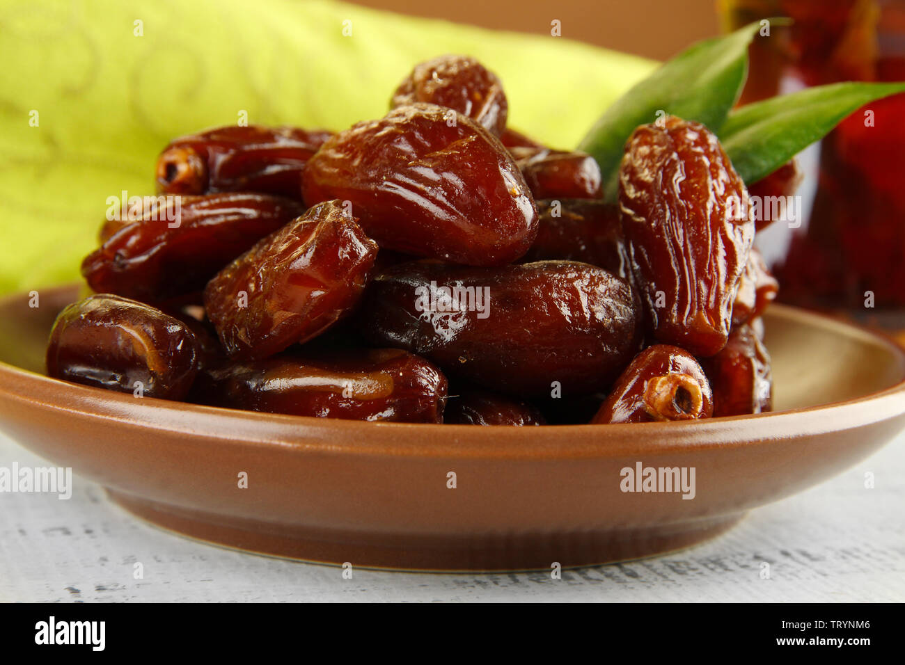 Dried dates on plate with cup of tea on table on fabric background ...