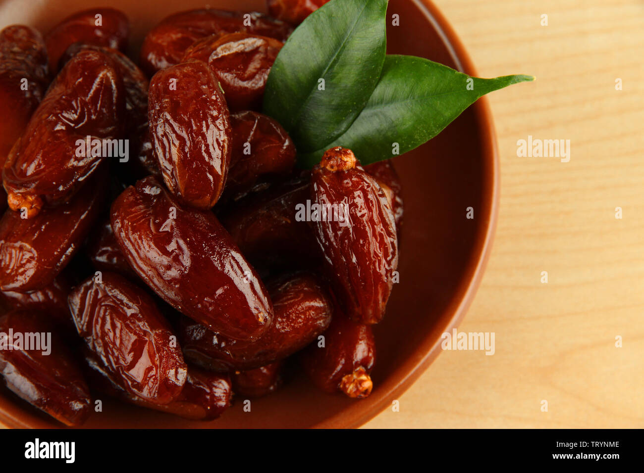 Dried dates on plate on wooden background Stock Photo - Alamy