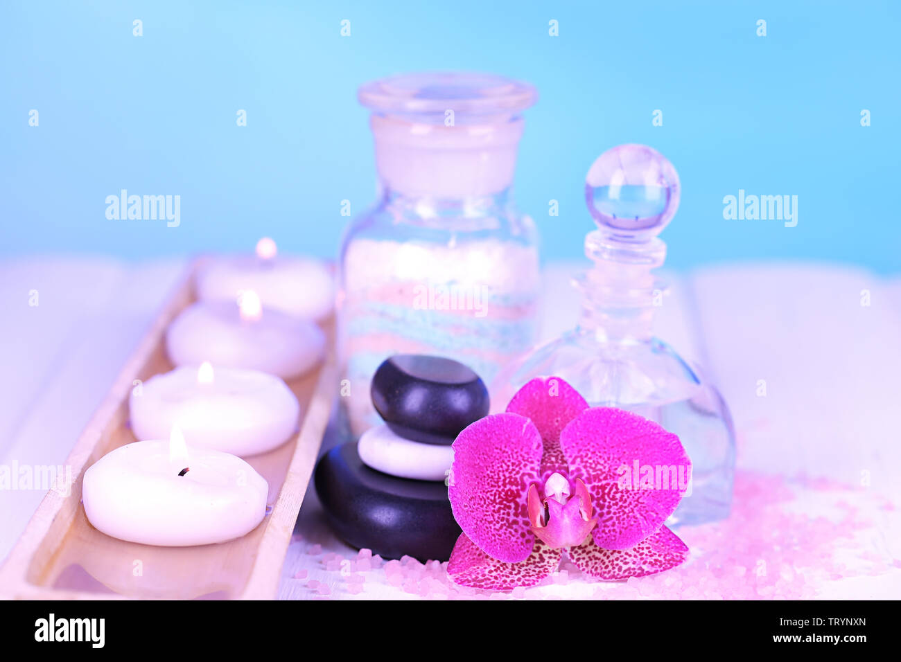 Beautiful spa setting with orchid on white wooden table on blue ...