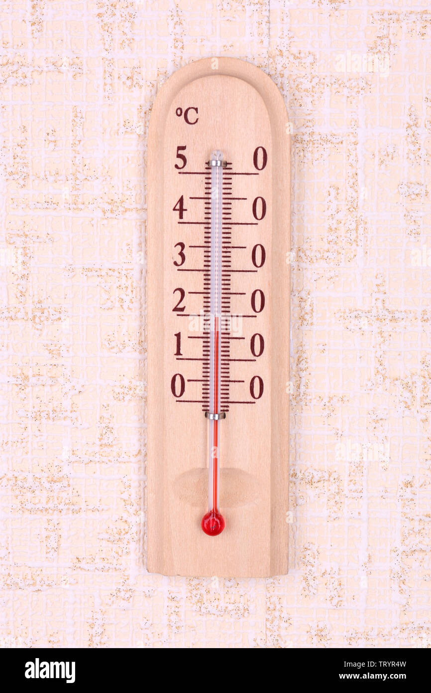 Thermometer on wall background Stock Photo - Alamy