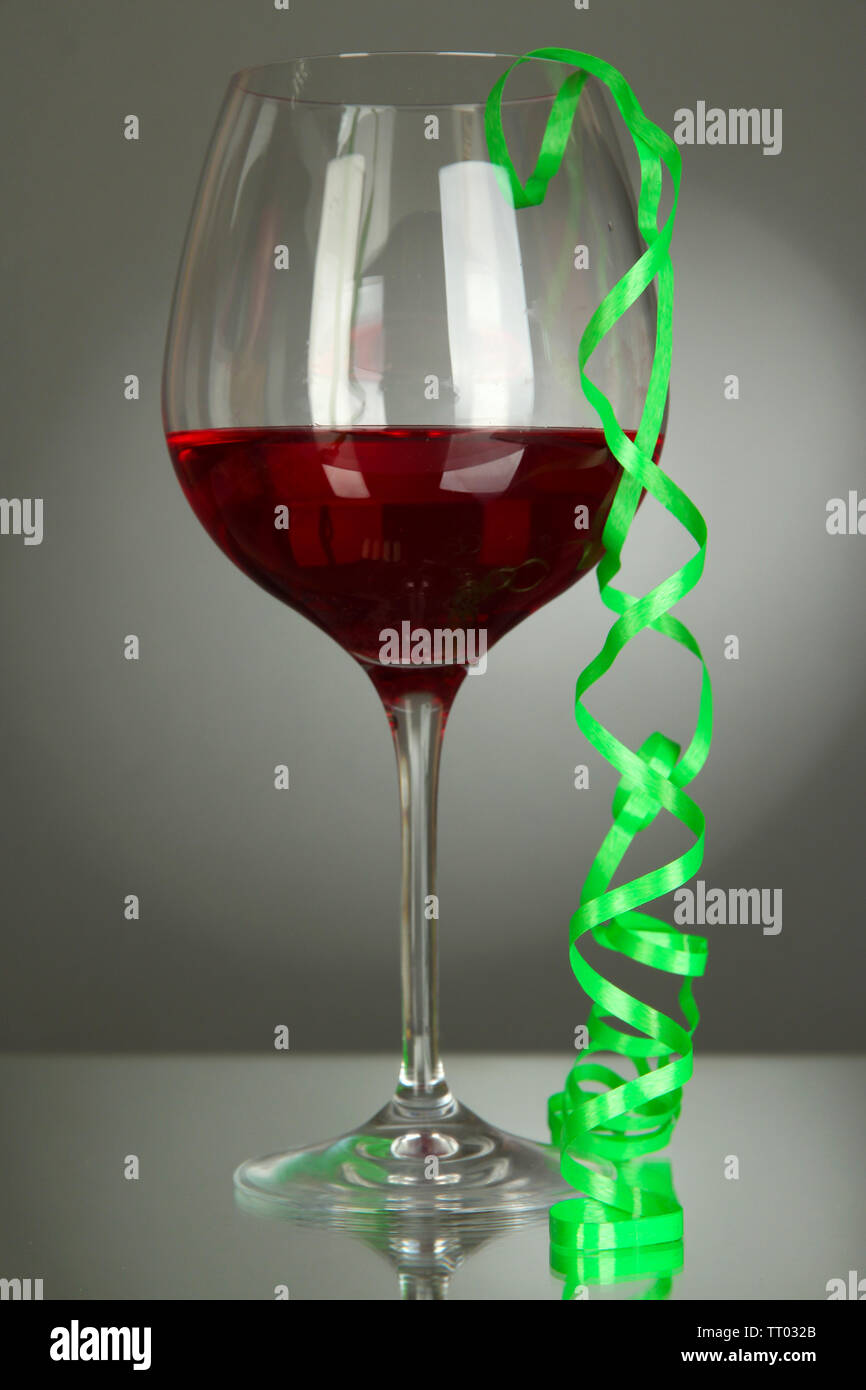 Glass of red wine and streamer after party on gray background Stock ...