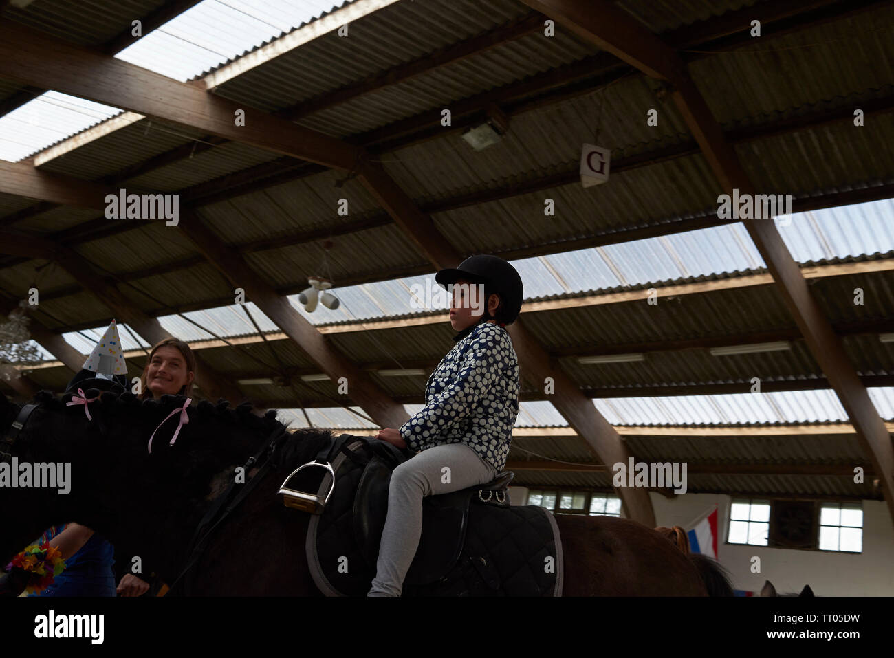 Kids learning horse riding and dressage at a horse riding school in ...