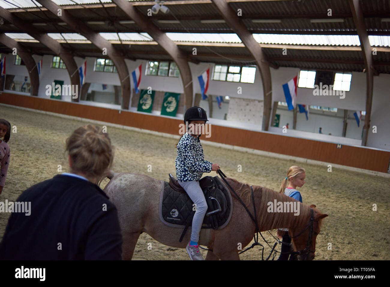 Kids learning horse riding and dressage at a horse riding school in ...