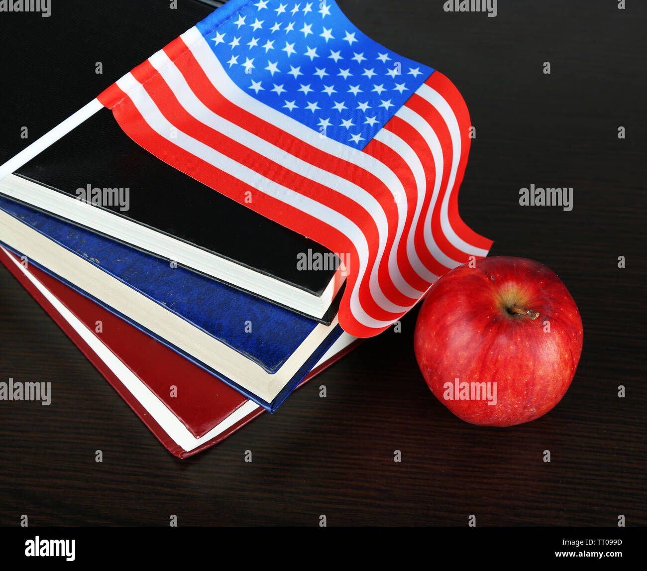 Composition of American flag, books and apple on wooden table ...