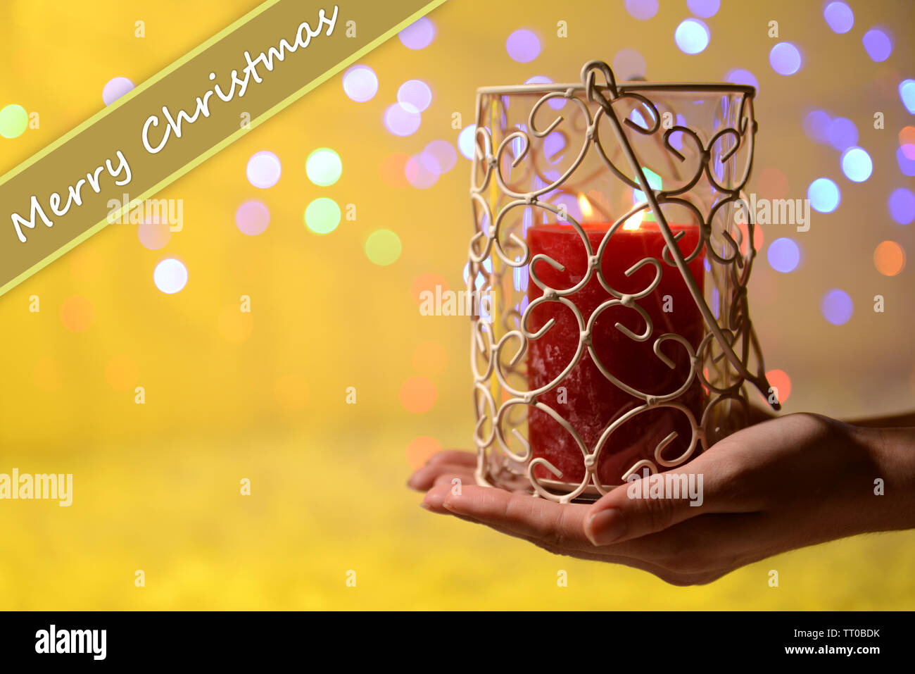 Candle in hand on blur lights background Stock Photo - Alamy