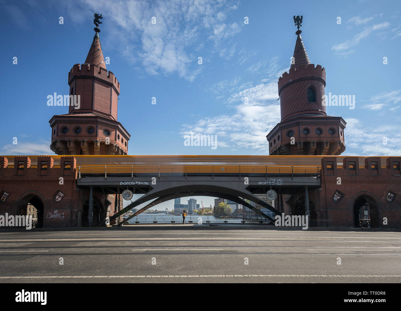 A musician and a train passing Oberbaum bridge in Berlin Stock Photo ...