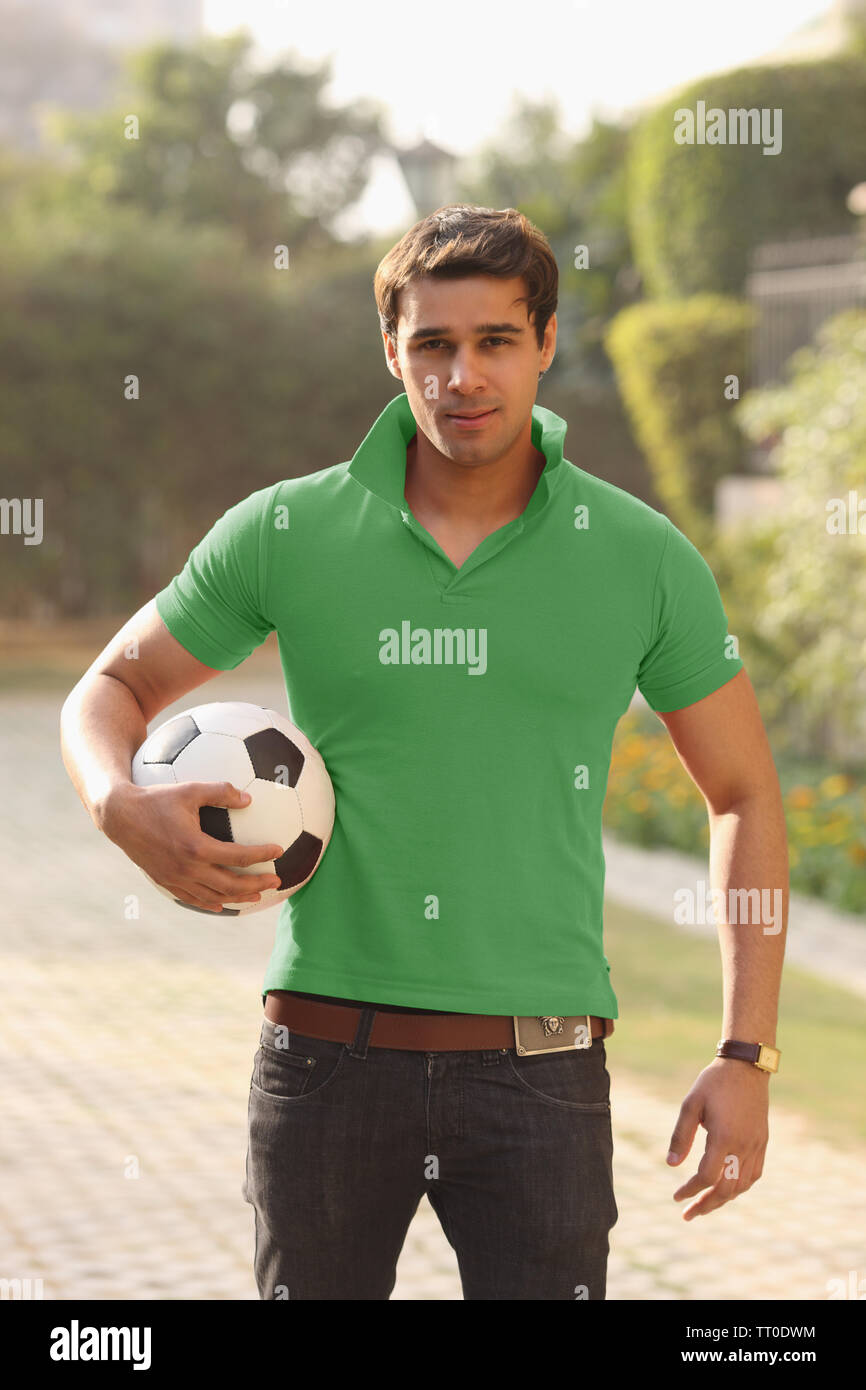Man holding a soccer ball under his arm Stock Photo - Alamy