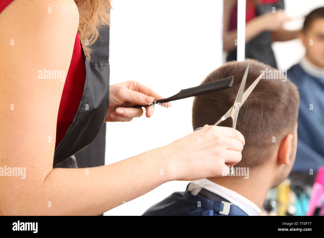 Beautiful girl hairdresser cut guy in beauty salon Stock Photo - Alamy