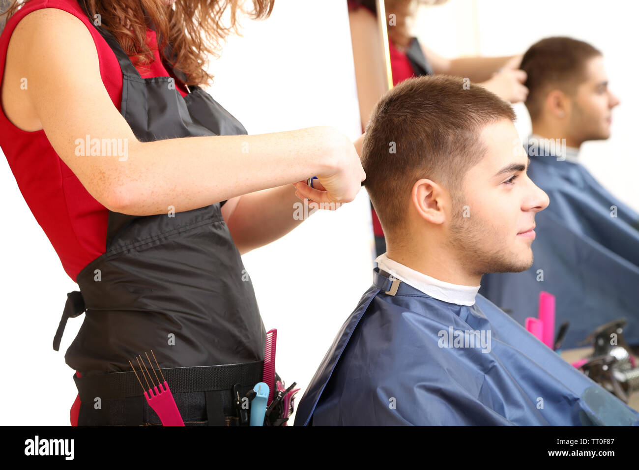 Beautiful girl hairdresser cut guy in beauty salon Stock Photo - Alamy