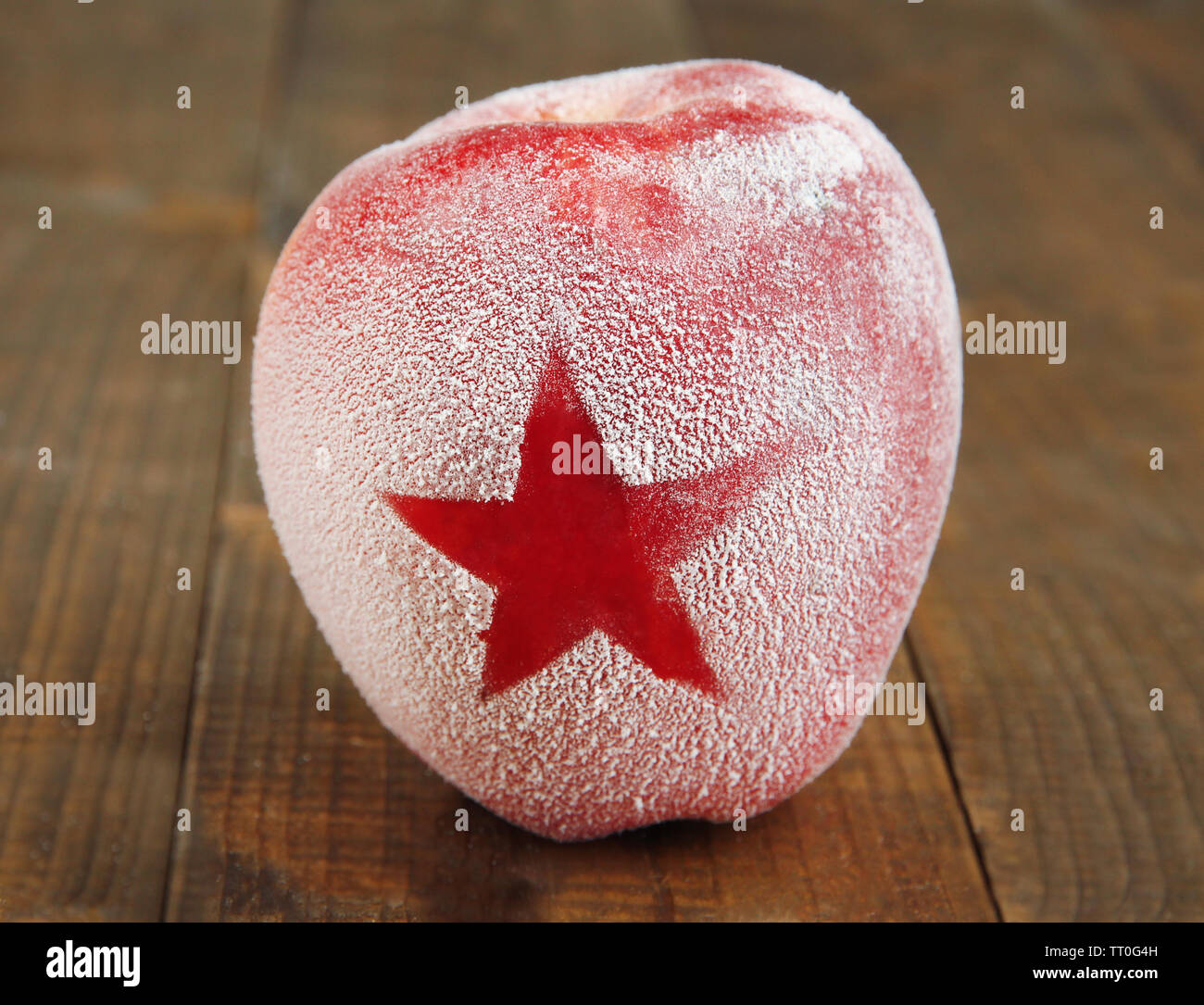 Holiday apple with frosted star on wooden background Stock Photo - Alamy