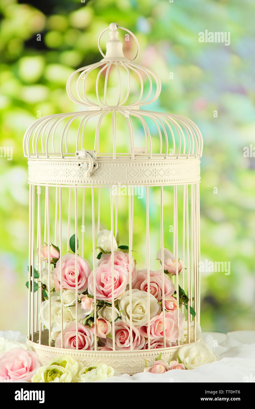 Beautiful decorative cage with beautiful flowers, on nature background ...