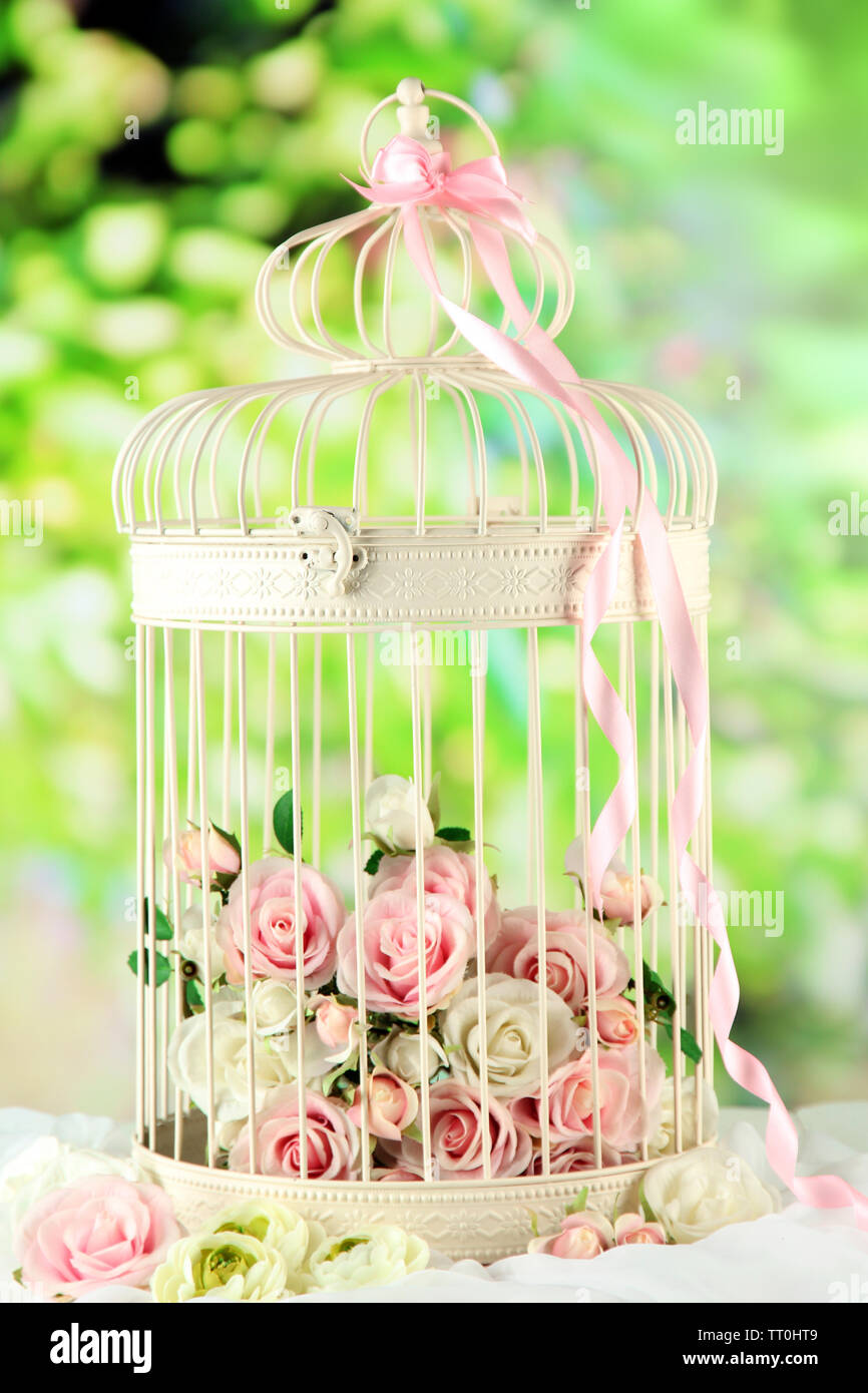 Beautiful decorative cage with beautiful flowers, on nature background ...