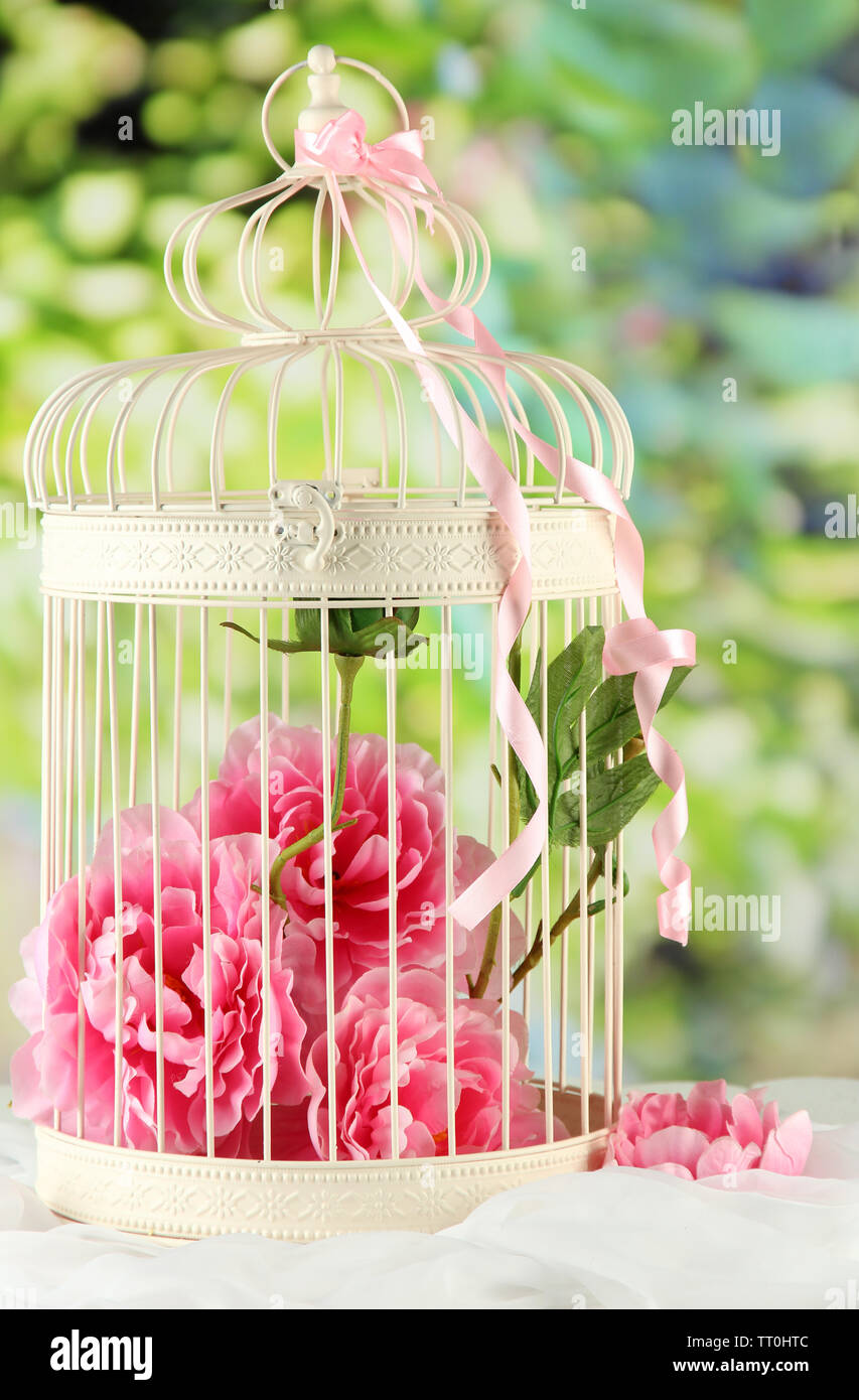 Beautiful decorative cage with beautiful flowers, on nature background ...