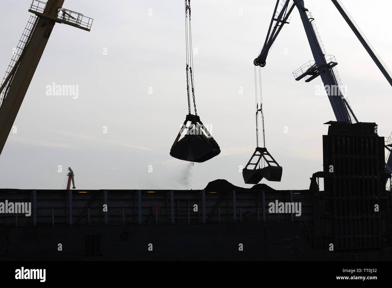 Loading of bulk cargo to the ships in the port terminal in the evening ...