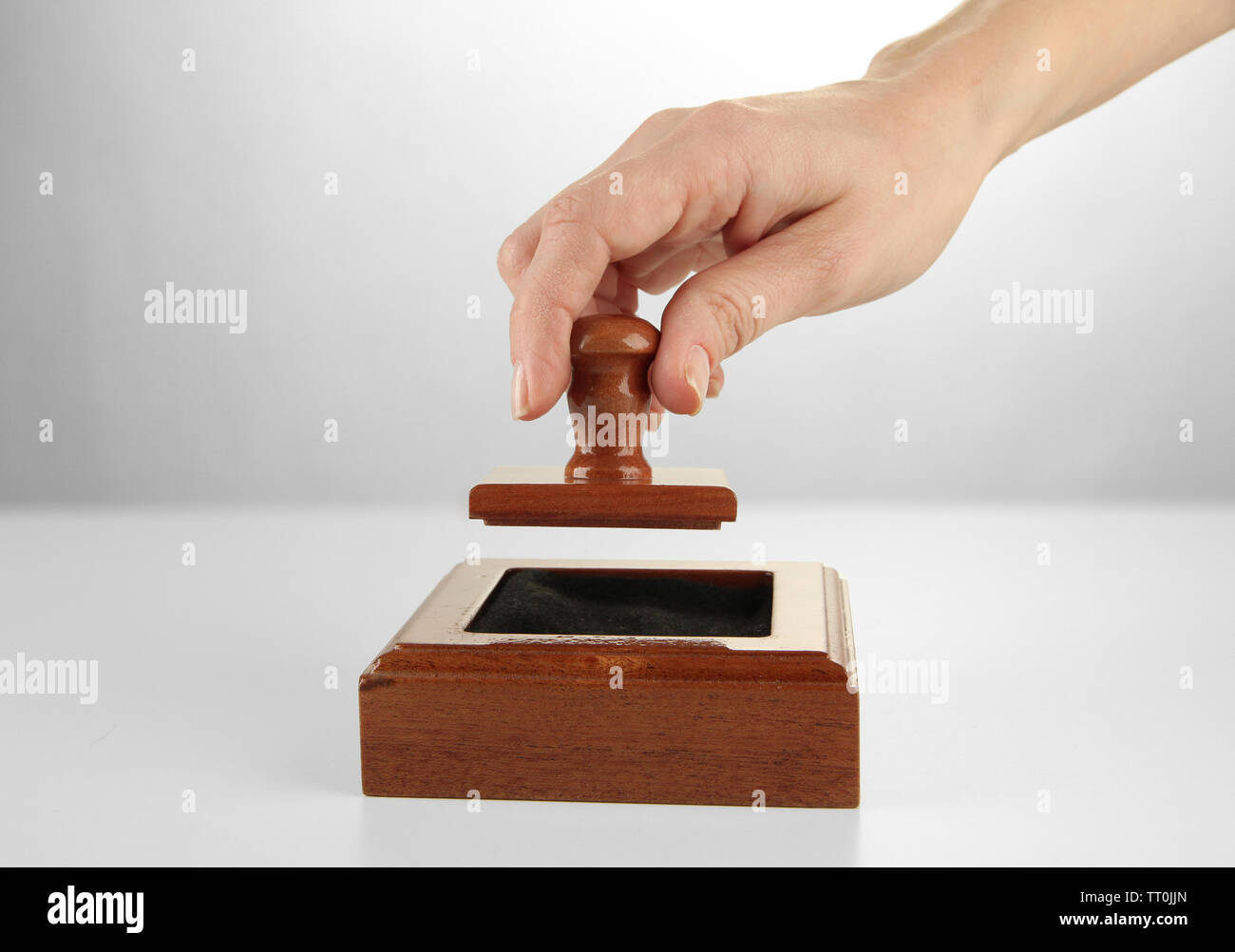 Hand holding wooden stamp isolated on white Stock Photo - Alamy