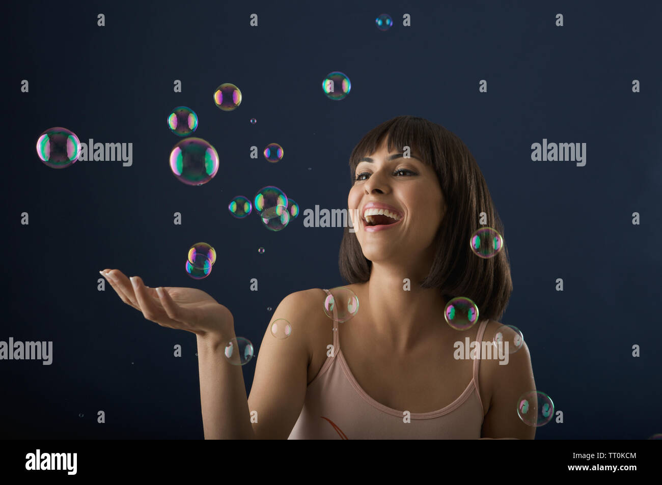 Woman holding hands beneath floating bubbles Stock Photo - Alamy