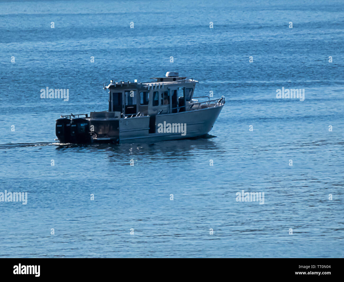 a metal speed boat on open calm blue water Stock Photo - Alamy