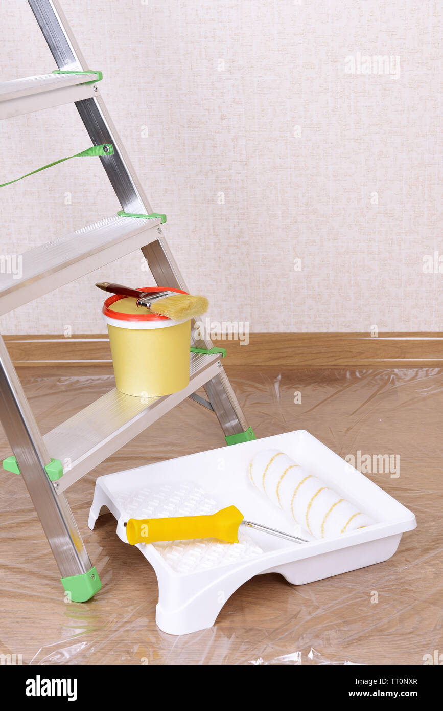Metal ladder and paint in room Stock Photo - Alamy