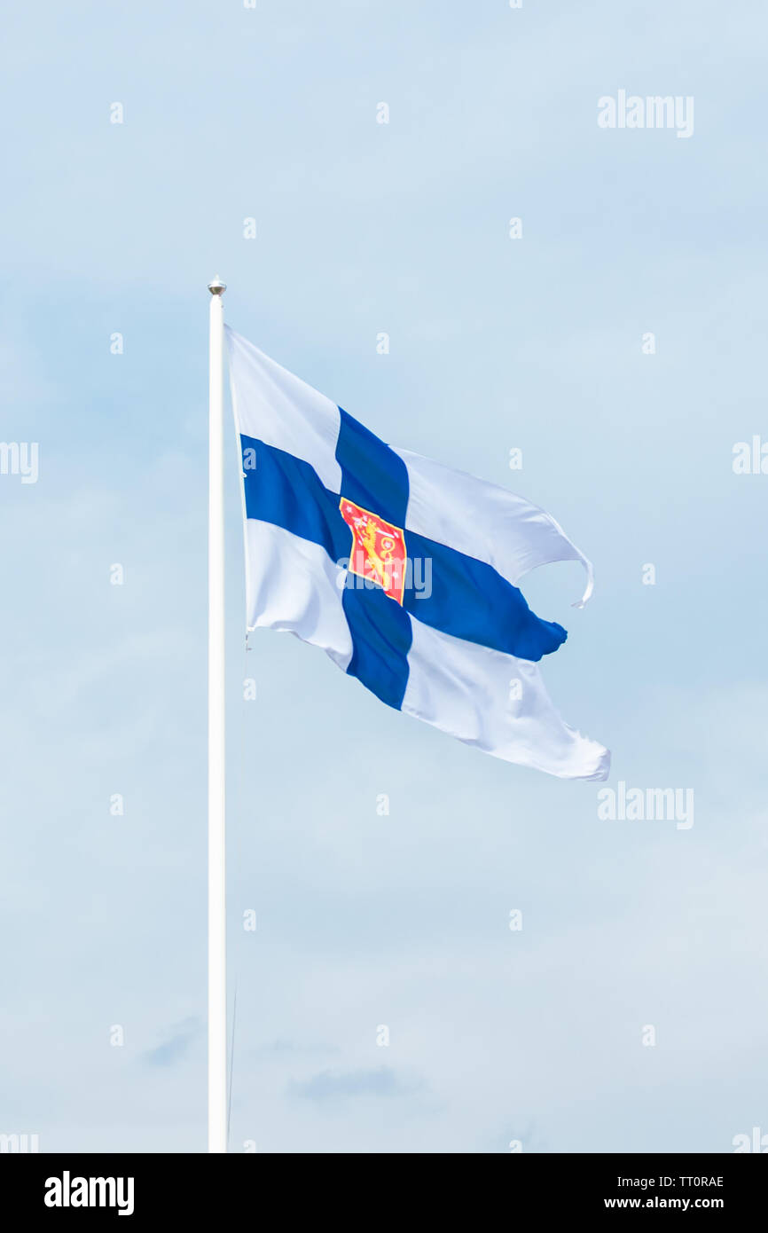 State flag of Finland with national coat of arms against blue sky Stock ...
