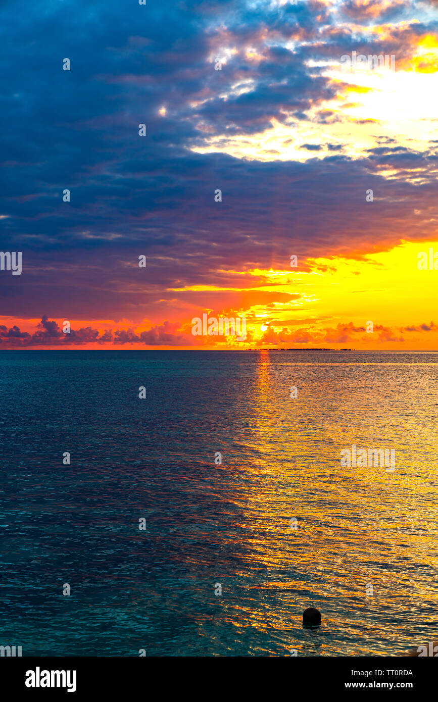 Sunrise glow across ocean framed by dark clouds Semporna Borneo Stock ...