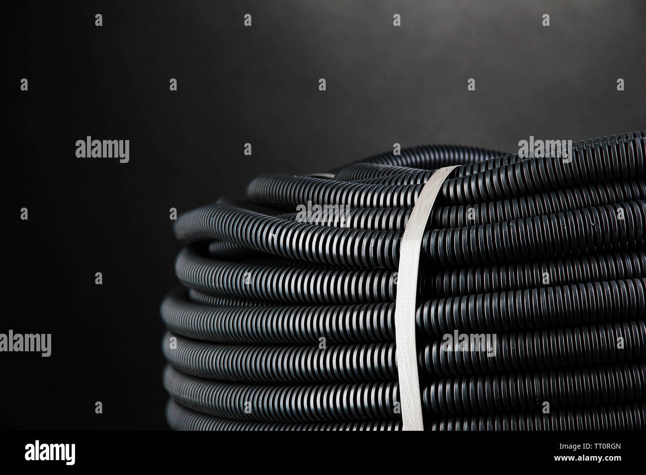 Black cable on black background Stock Photo - Alamy