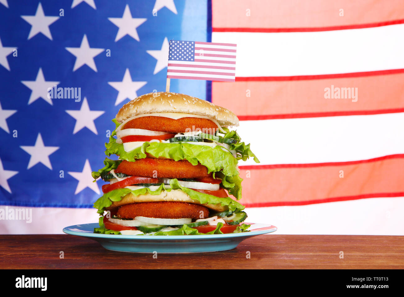 Huge burger on color plate on USA flag background Stock Photo - Alamy