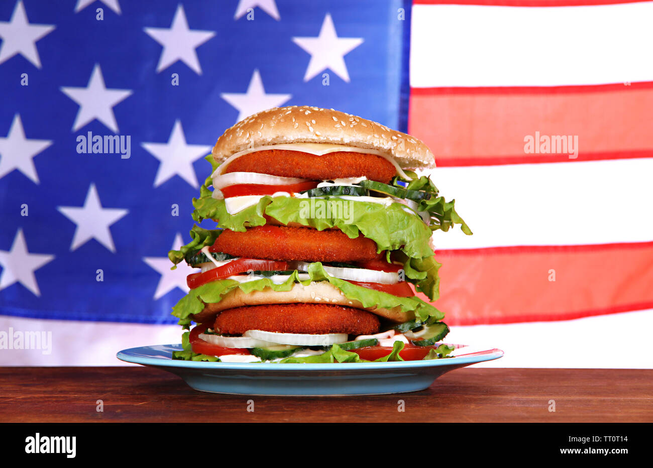 Huge burger on color plate on USA flag background Stock Photo - Alamy