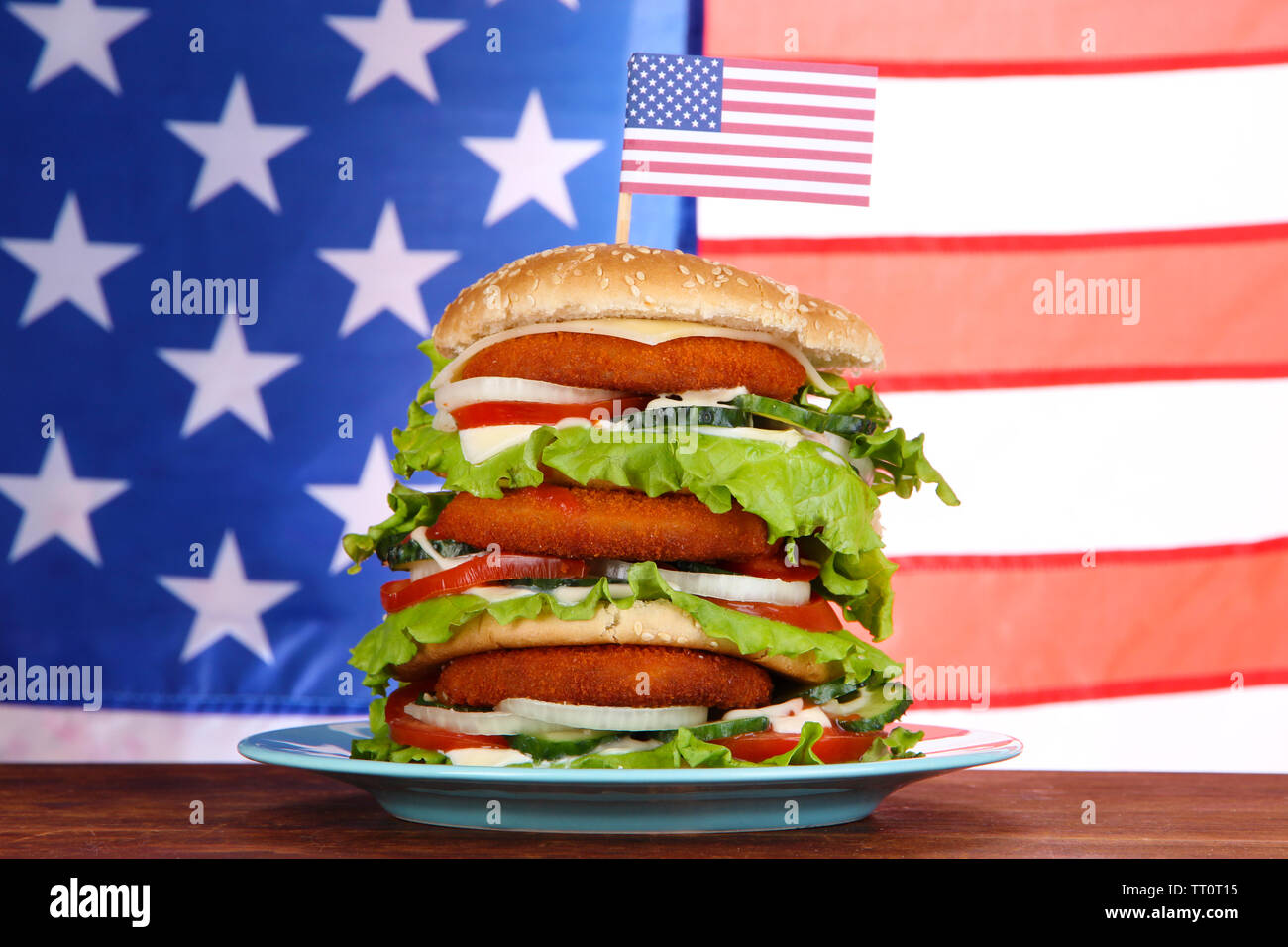 Huge burger on color plate on USA flag background Stock Photo - Alamy