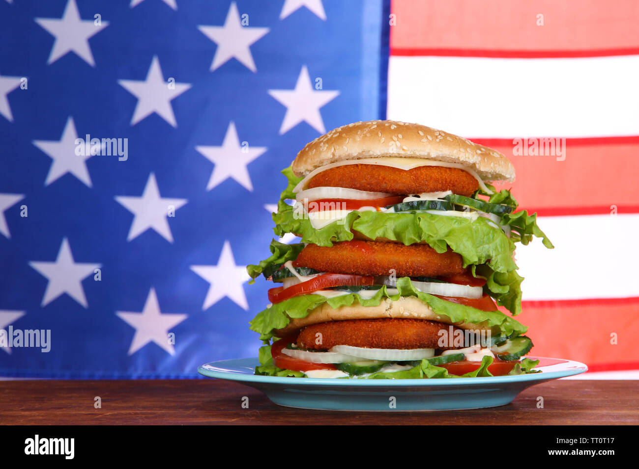 Huge burger on color plate on USA flag background Stock Photo - Alamy