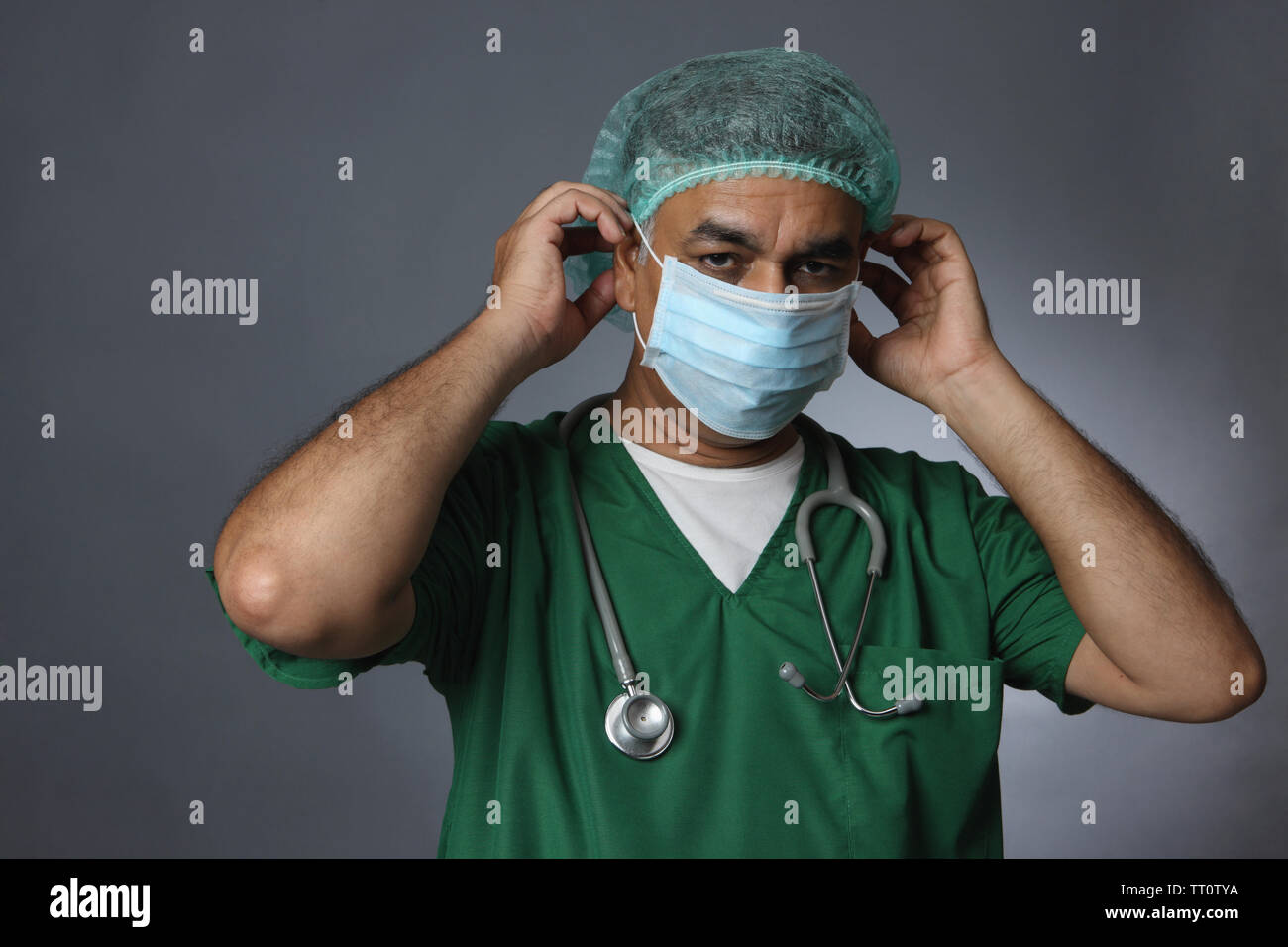 Male surgeon putting on surgical mask Stock Photo - Alamy