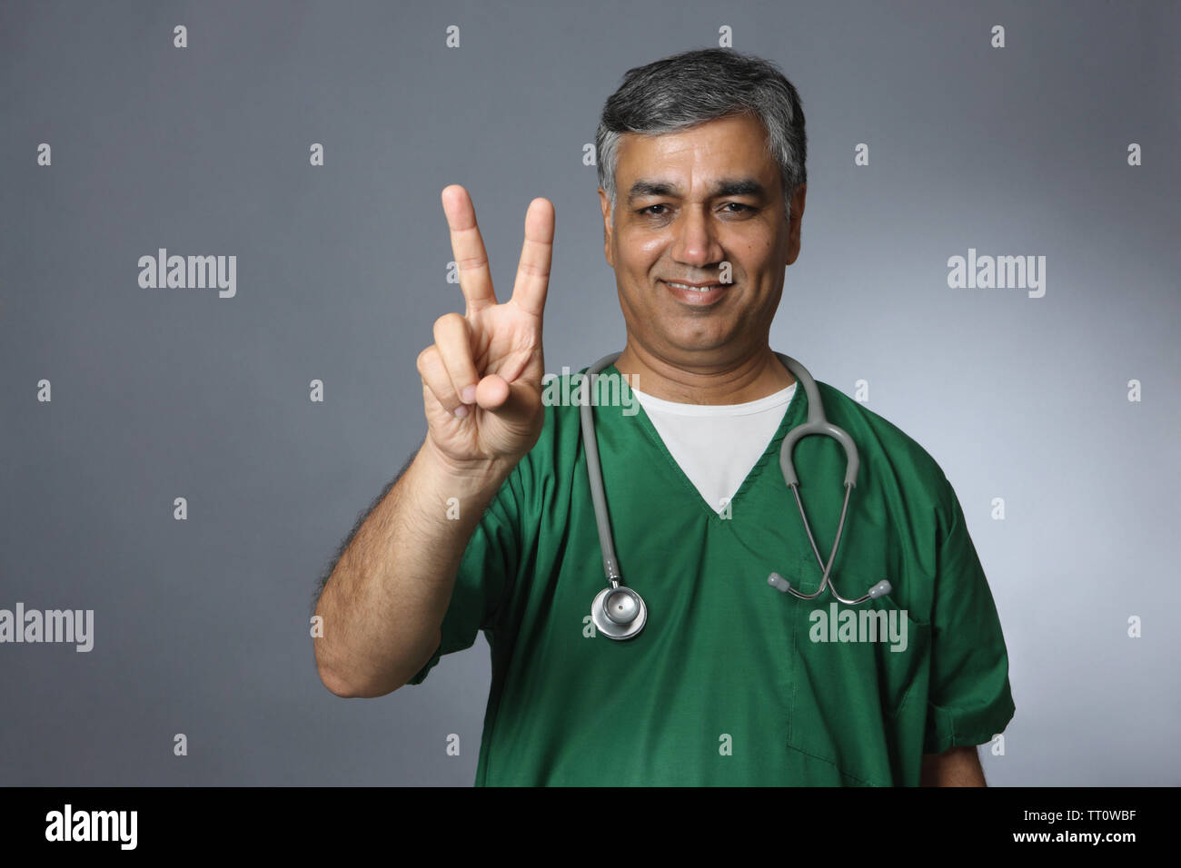 Portrait of a male surgeon showing victory sign Stock Photo - Alamy