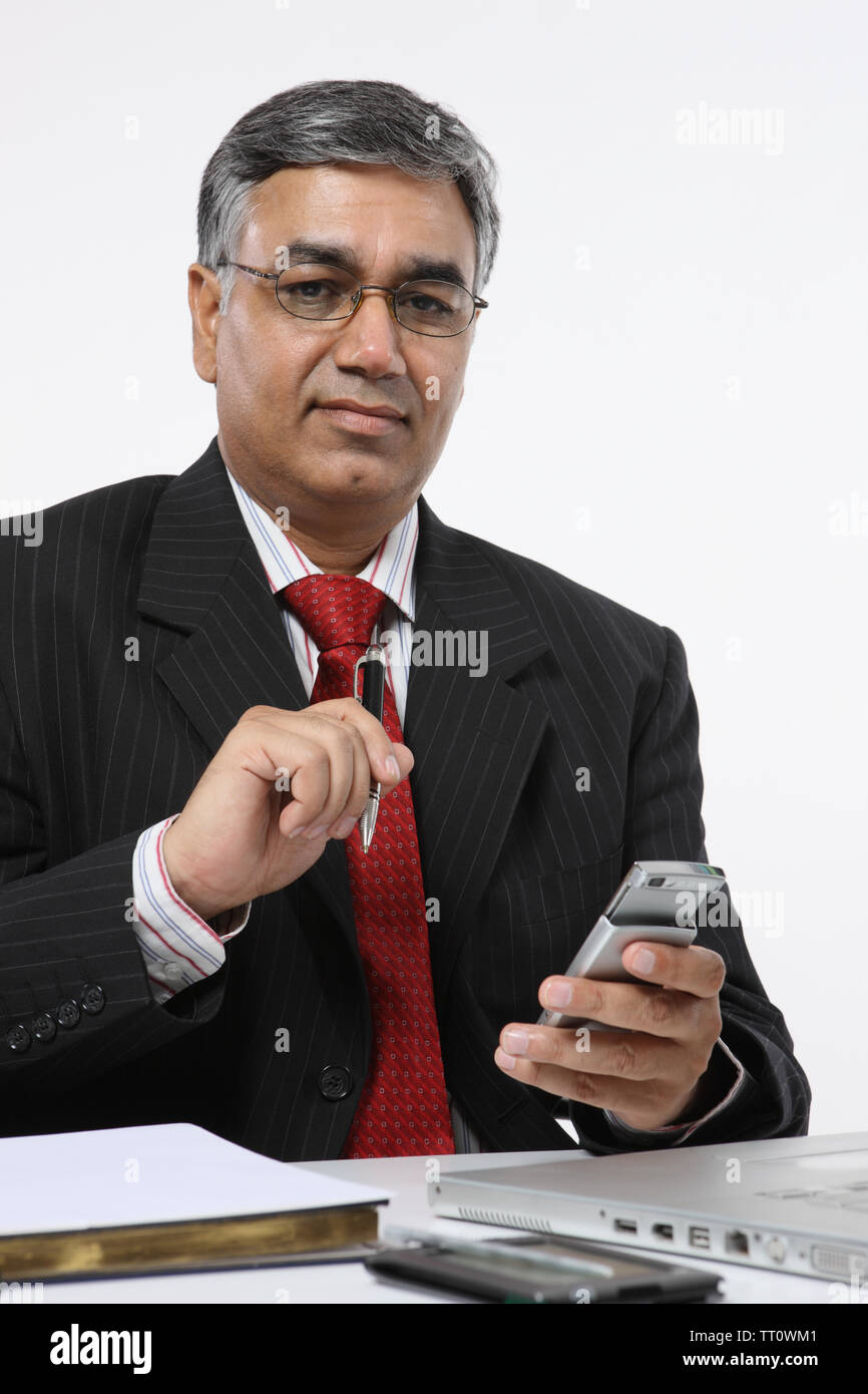 Indian businessman using a mobile phone in an office Stock Photo - Alamy