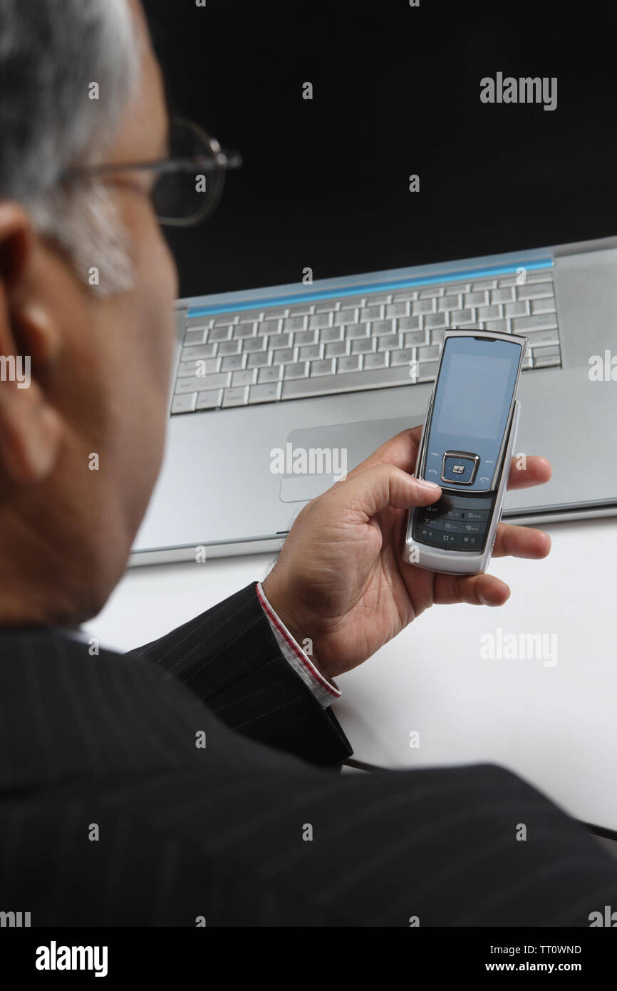 Businessman using a mobile phone in an office Stock Photo - Alamy