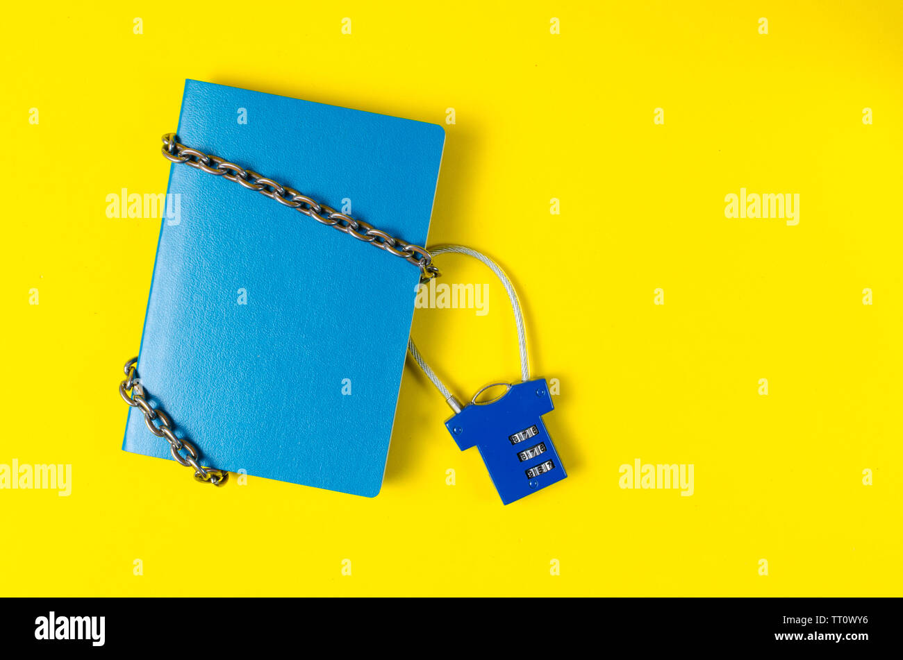 Passport is closed on the lock and wrapped chain.On yellow background ...