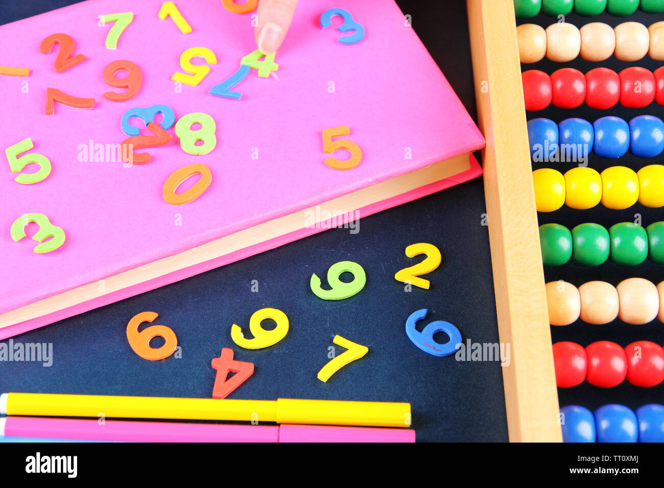 Colorful numbers, abacus, books and markers on school desk background ...