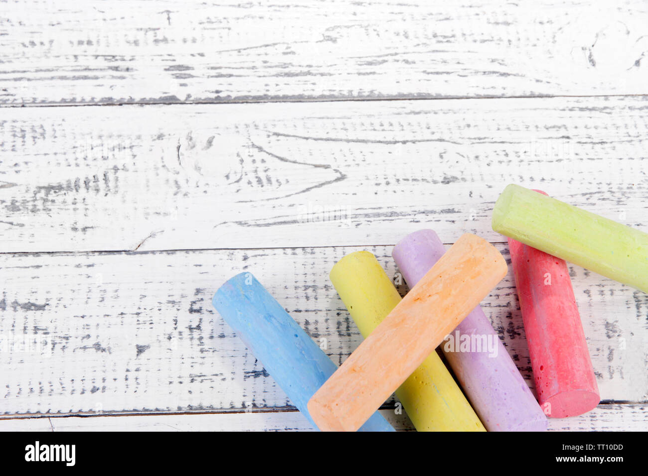 Chalks in variety of colors, on wooden background Stock Photo - Alamy