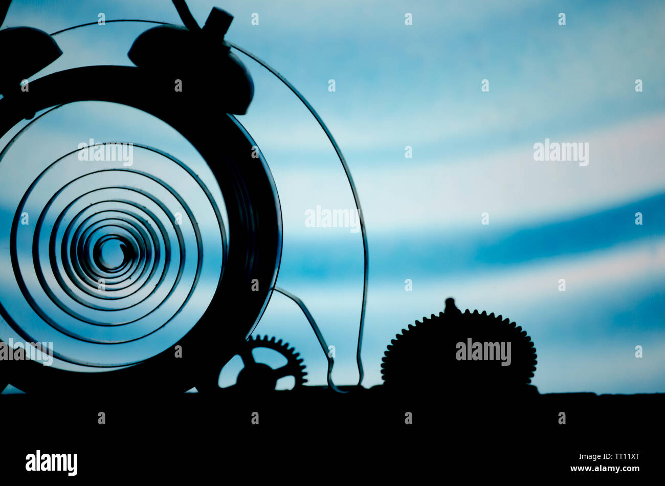 Broken alarm clock with springs and gears scattered on the background ...
