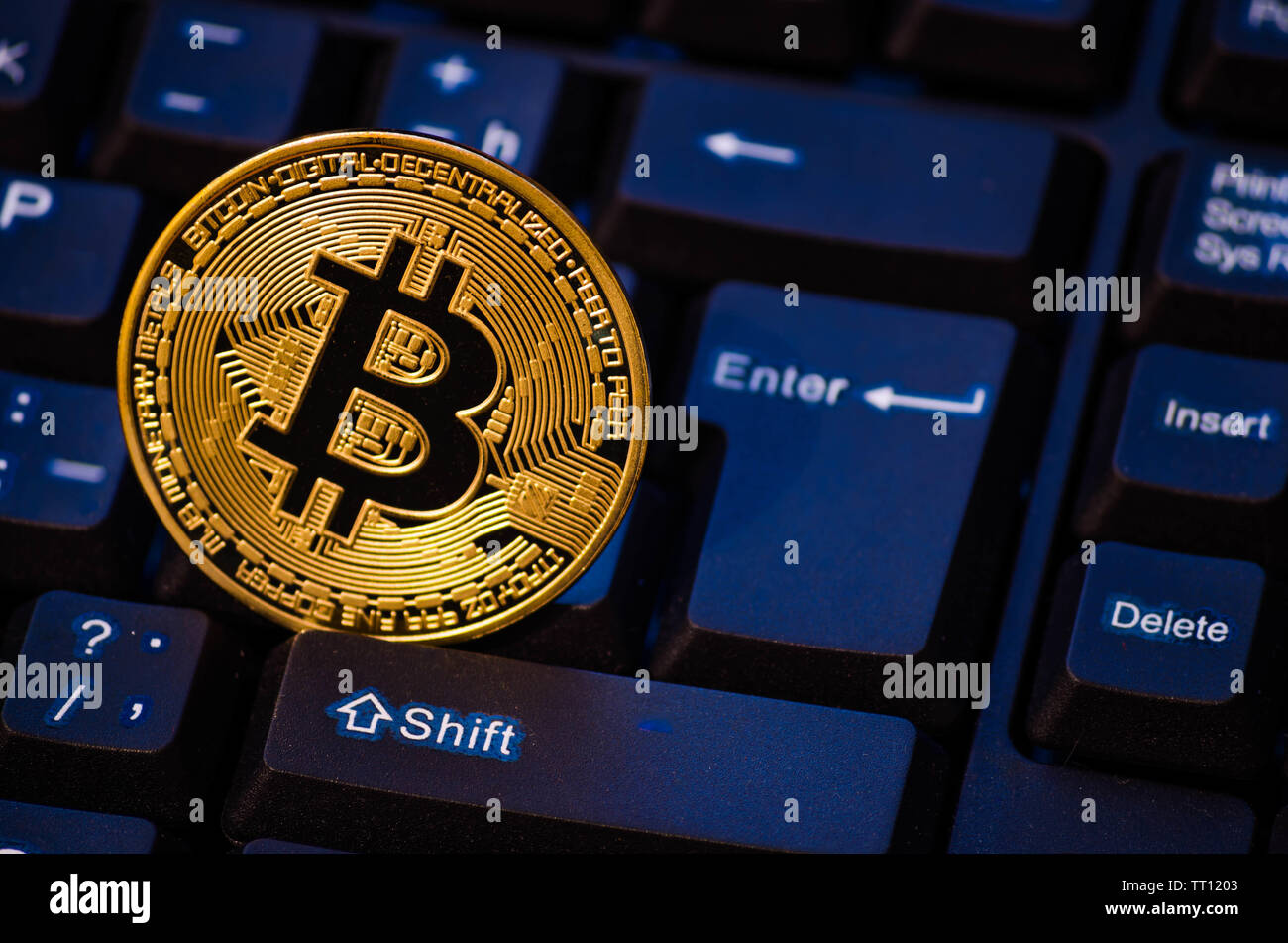 Gold coin bitcoin on the keyboard in blue from the monitor Stock Photo ...