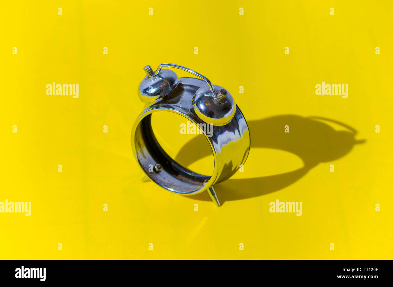 Old disassembled alarm clock on yellow background with bright sunlight ...