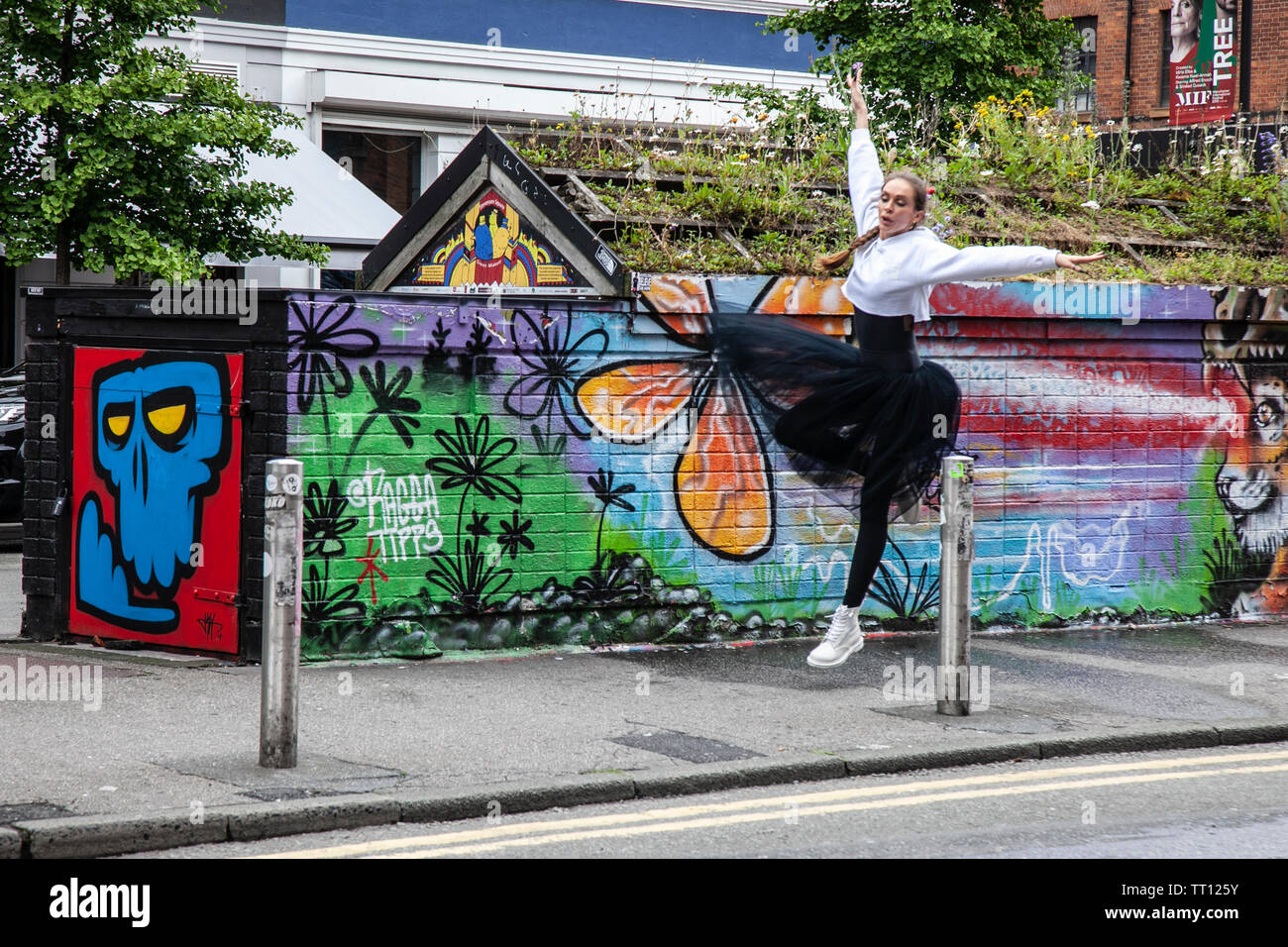 Graffiti wall and dancer. Northern quarter urban street art. Shops ...