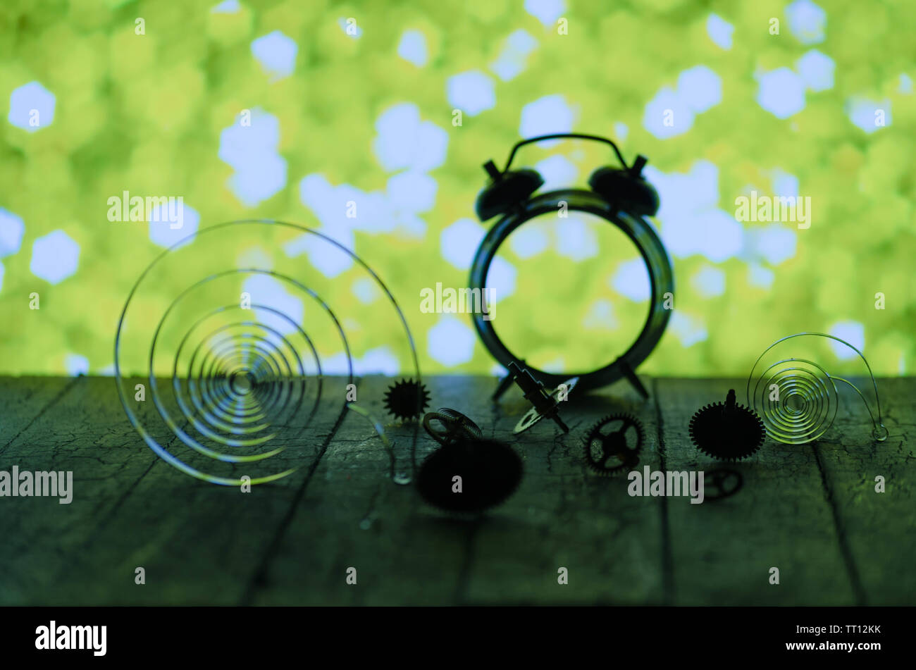 Broken alarm clock with springs and gears scattered on the background ...