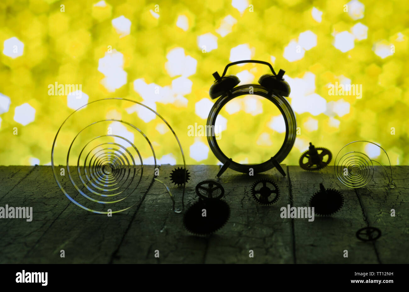 Broken alarm clock with springs and gears scattered on the background ...
