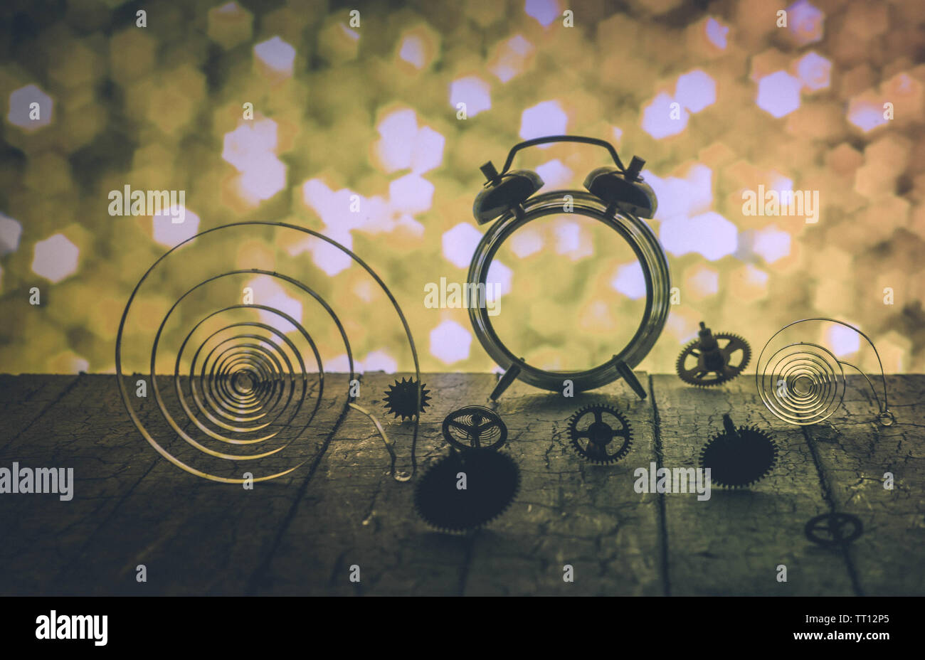 Broken alarm clock with springs and gears scattered on the background ...