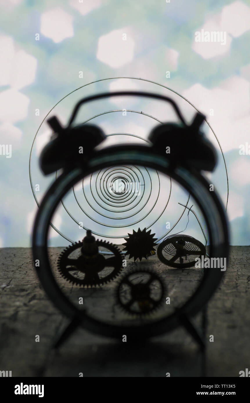 Broken alarm clock with springs and gears scattered on the background ...