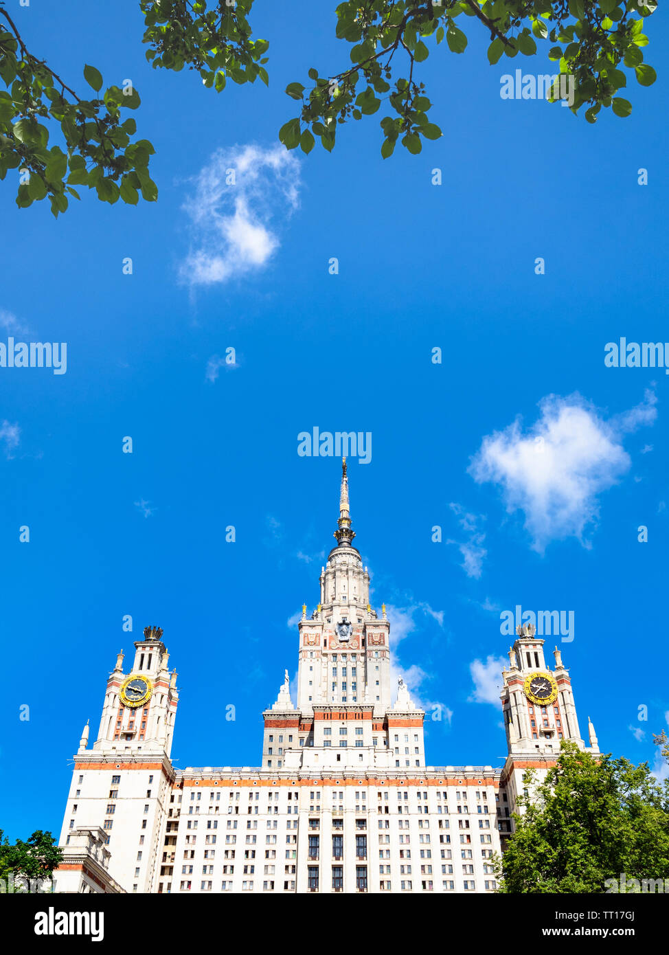 green leaves, blue sky and east facade of The Main Building of Moscow ...