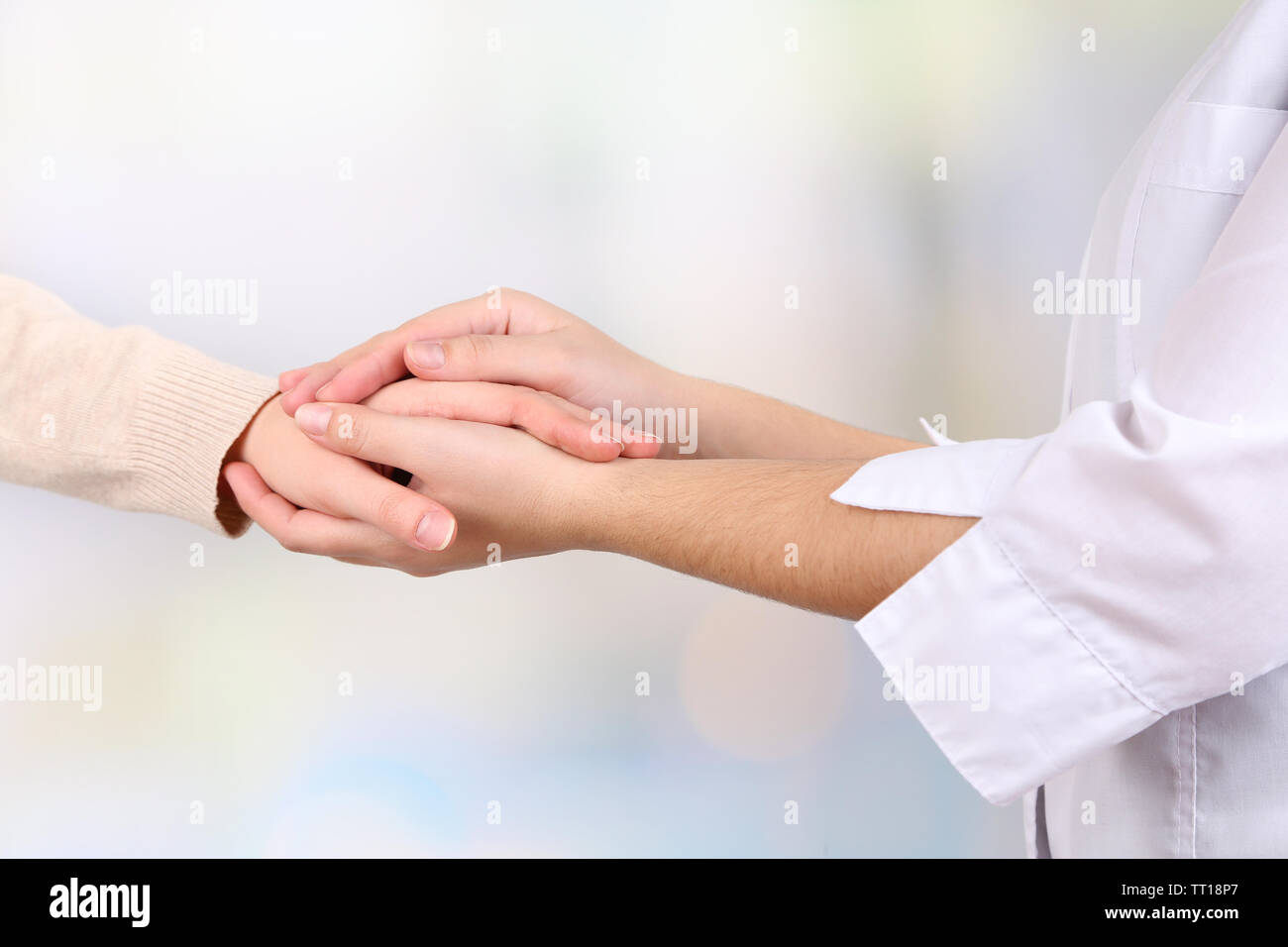 Medical doctor holding hand of patient, on light background Stock Photo ...